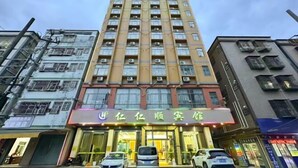 Um hotel de vários andares com uma placa grande no centro.