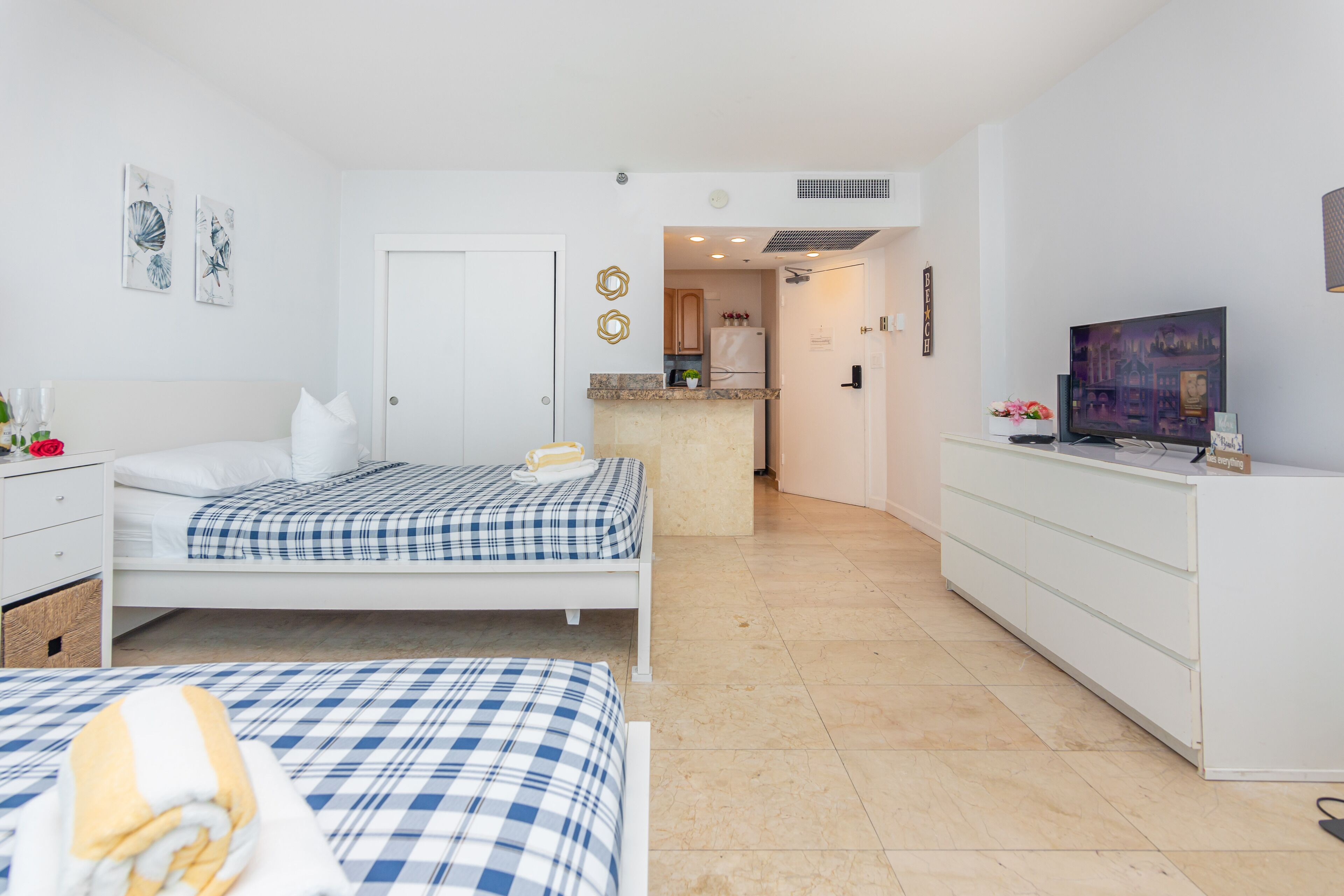 Quarto de hotel moderno com cama, escrivaninha e televisão.