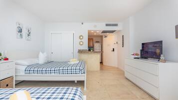 Quarto de hotel moderno com cama, escrivaninha e televisão.