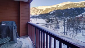 Uma varanda com vista para montanhas cobertas de neve e um céu claro.