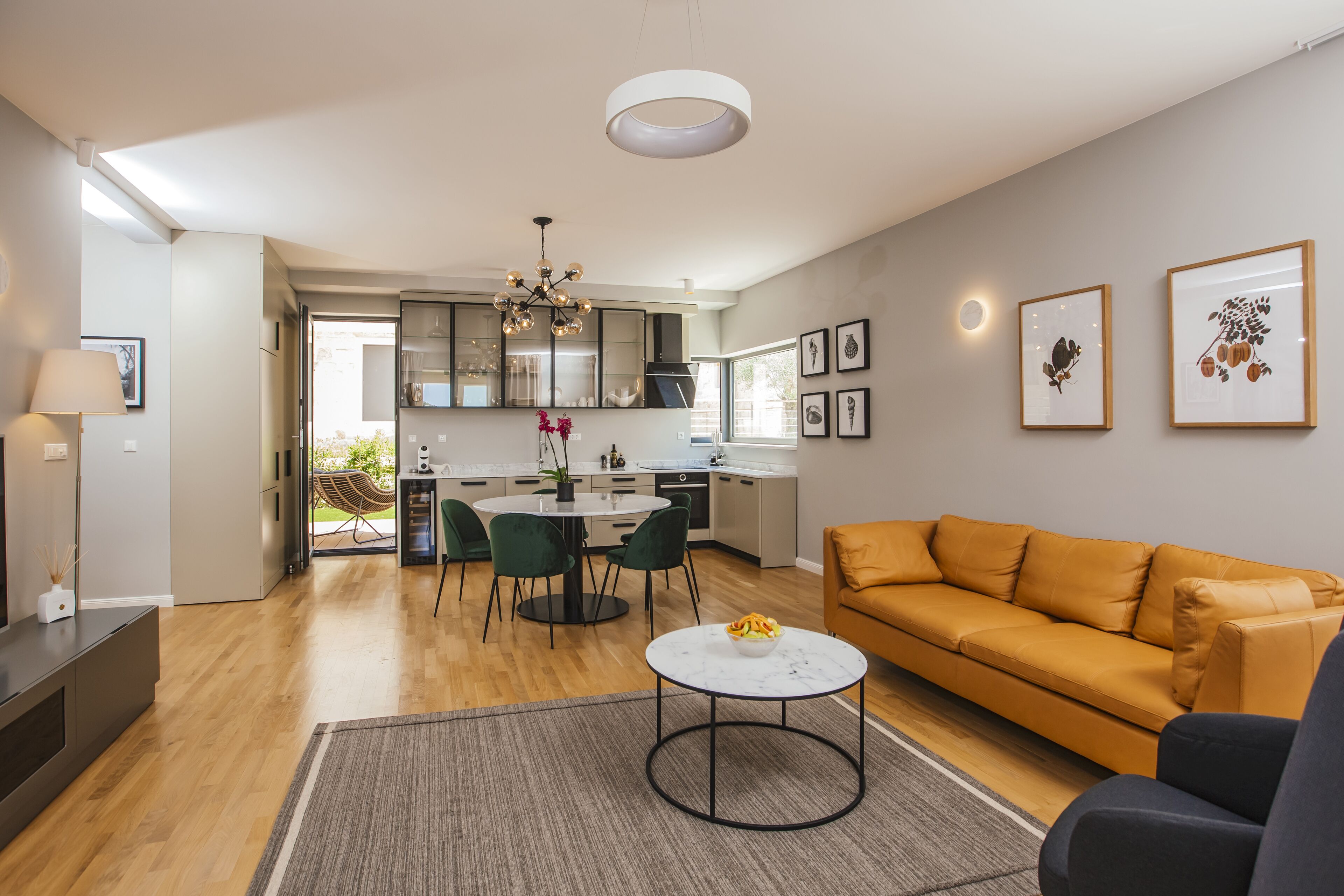 Uma sala de estar moderna com sofá, mesa de centro e área de jantar com cadeiras.