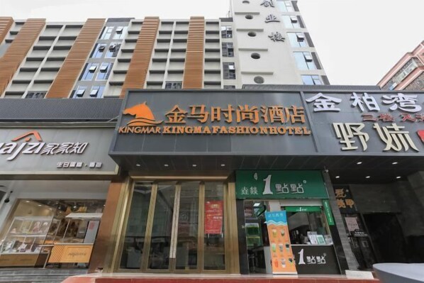 Fachada de hotel com placas indicando 'Kingma Kingma Fashion Hotel' e 'Jiazi Home Knowledge'.