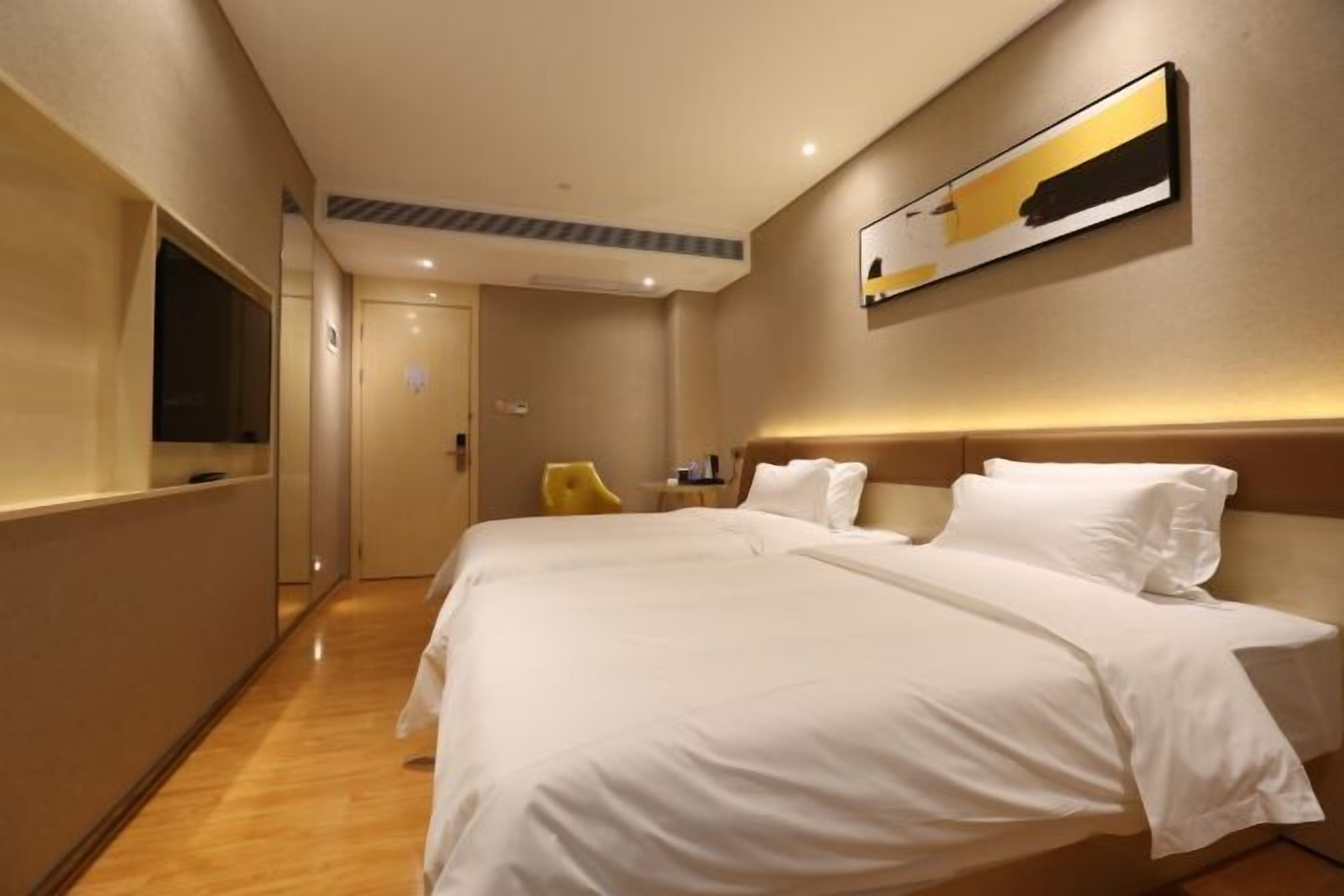 Quarto de hotel com uma cama grande, televisão de tela plana na parede e design moderno.