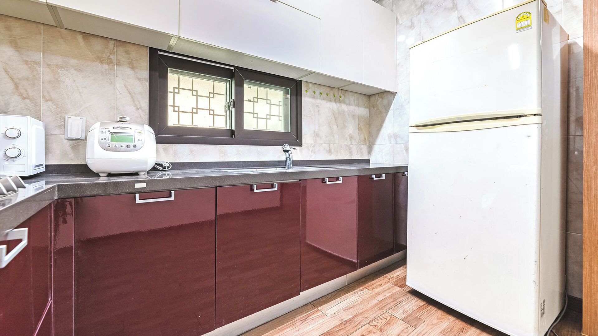 Cozinha equipada com micro-ondas, torradeira e frigorífico.