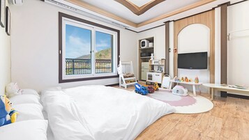 Quarto de hotel com uma cama grande, televisão, escrivaninha e varanda com vista.