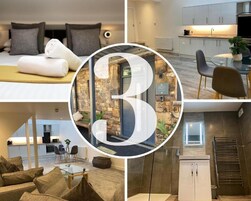 Quarto de hotel moderno com cama, banheiro, sala de estar com sofá e cozinha.