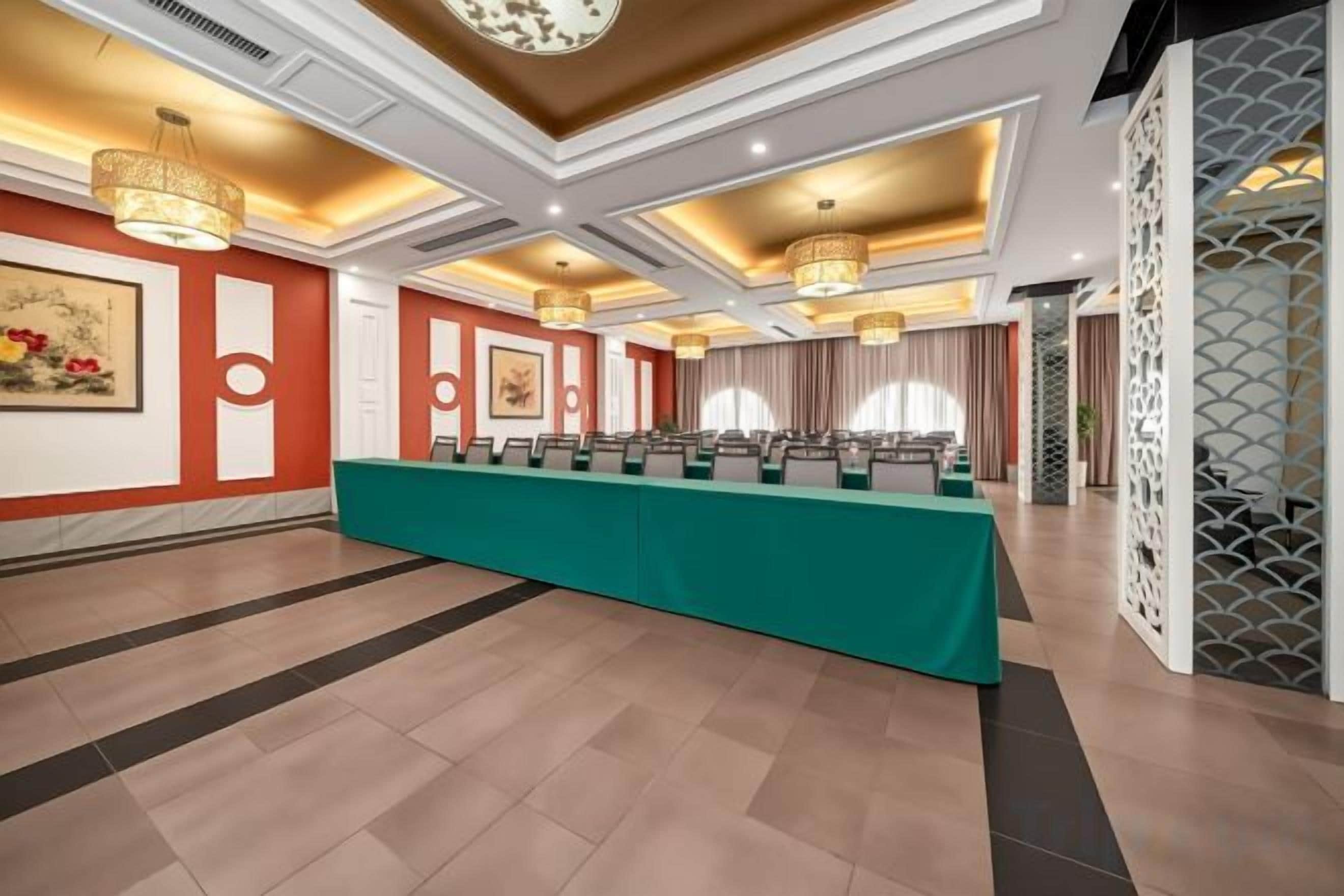 Uma sala de conferências com uma mesa comprida, várias cadeiras e um teto decorativo.