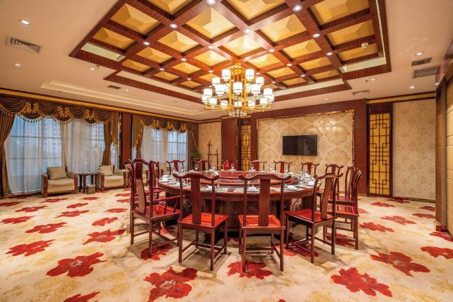 Uma sala de conferências com uma mesa redonda, cadeiras e um candelabro.