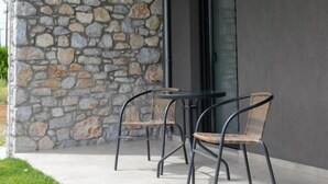 Uma área de estar coberta ao ar livre, com paredes de pedra e design moderno.