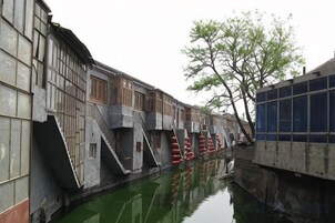 Um canal estreito ladeado por edifícios tradicionais com vários níveis e escadarias.