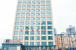 Um edifício com vários andares, fachada plana e uma grade de janelas.