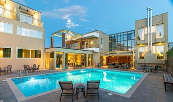 Um hotel moderno com piscina, área de estar ao ar livre e um terraço coberto.