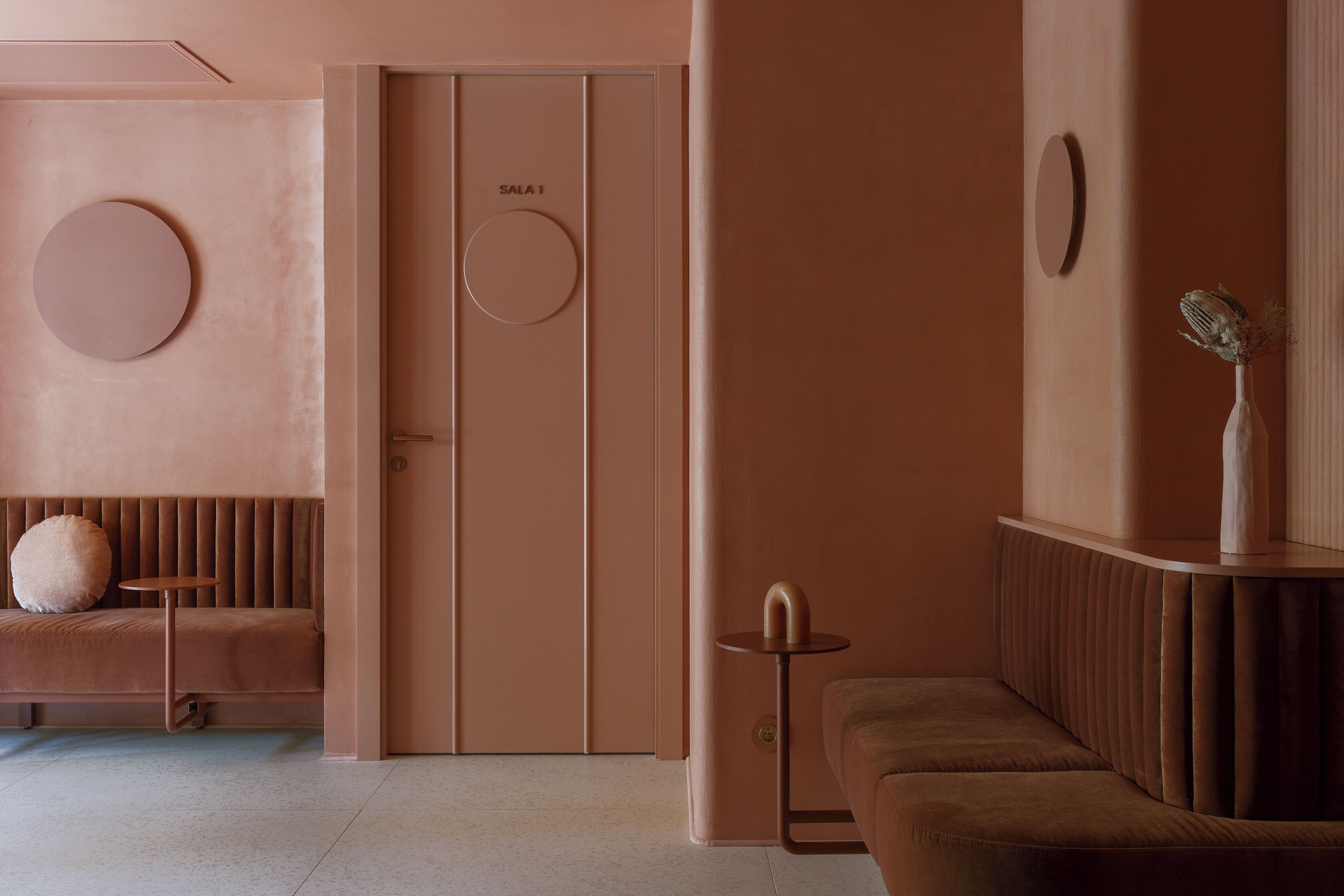 Um interior moderno com um sofá, uma mesinha e um vaso decorativo.