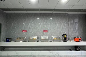 Disposição de buffet com diversas estações de comida e uma balança digital.