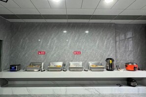 Disposição de buffet com diversas estações de comida e uma balança digital.