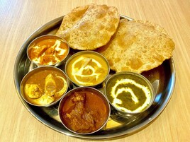 Um prato com diversos pratos indianos, incluindo curry e pão.