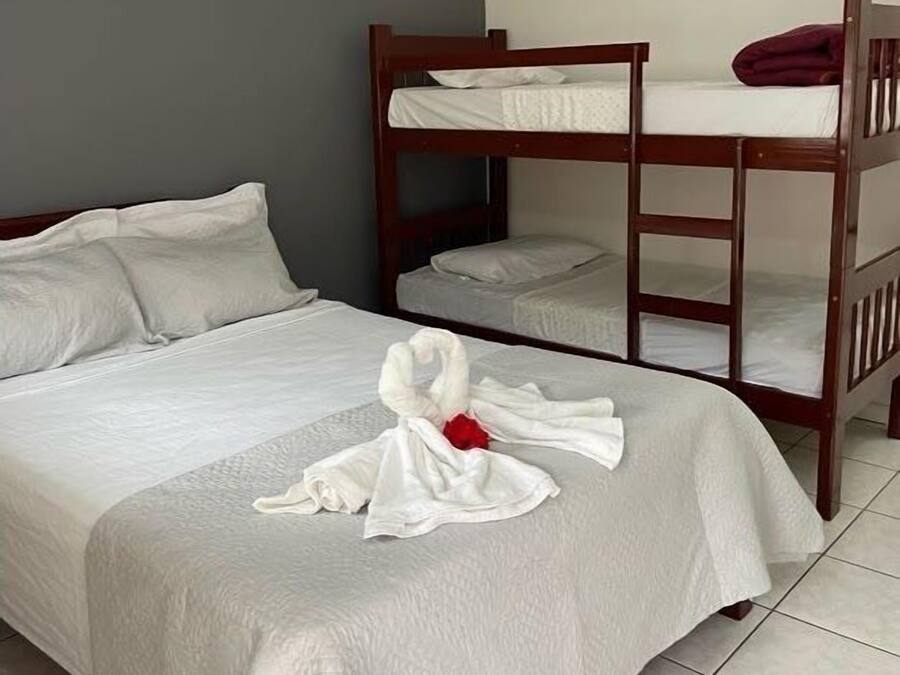 Quarto de hotel com uma cama de solteiro e duas beliches.