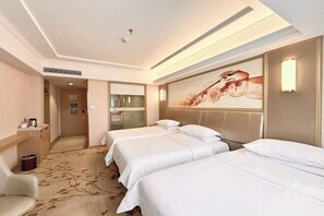 Quarto de hotel com duas camas, uma escrivaninha, uma cadeira e uma obra de arte na parede.