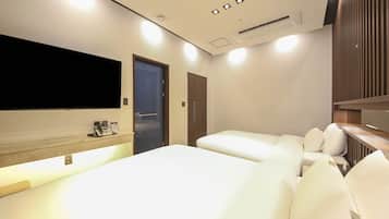 Quarto de hotel com uma cama grande, mesas de cabeceira, uma televisão e uma porta para o banheiro.