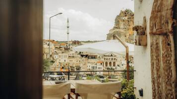 Vista de um horizonte urbano com edifícios históricos, um minarete e uma estrutura em forma de tenda branca.