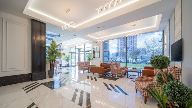 Um hall amplo com design moderno, com uma variedade de áreas de estar e uma grande janela com vista para a cidade.