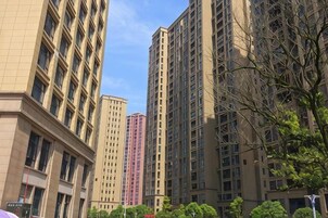 Um edifício alto com vários andares, janelas amplas e céu claro.