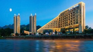 Um hotel com um edifício grande e moderno, e duas torres altas ao fundo.