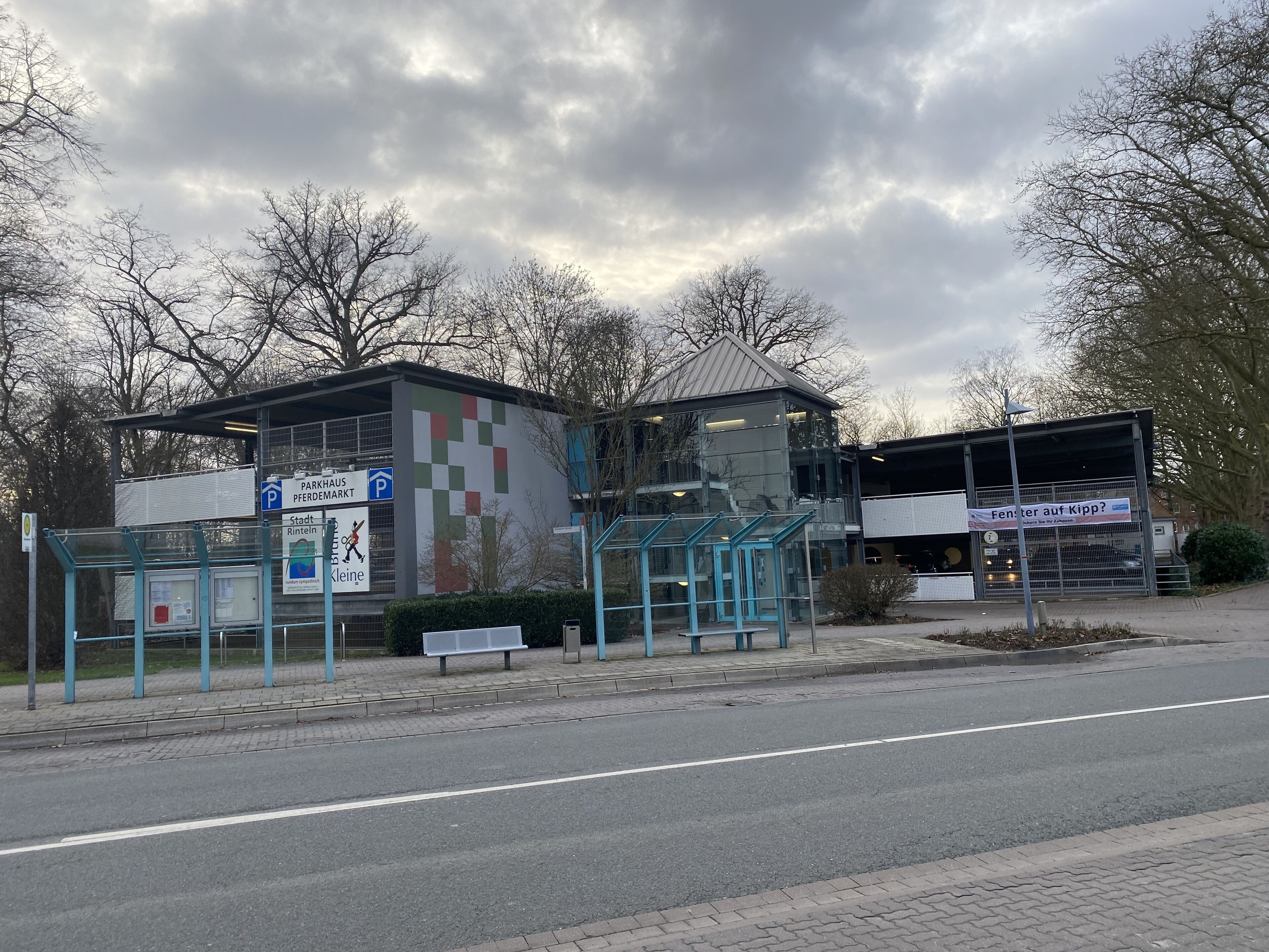 Um estacionamento com fachada de vidro e uma placa com a inscrição 'Parkhaus Perferdemarkt'.
