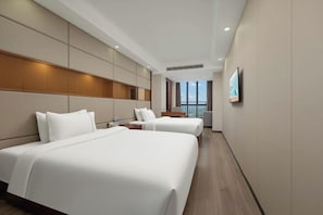 Quarto de hotel com duas camas, uma janela grande e vista para o céu.