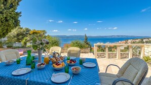 Mesa posta para o café da manhã com vista para o mar e montanhas.
