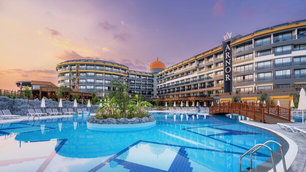 Um hotel com uma grande piscina, várias varandas e uma cúpula laranja marcante.
