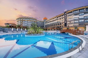 Um hotel com uma grande piscina, várias varandas e uma cúpula laranja marcante.
