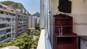 Uma varanda com vista para a cidade e para uma montanha.