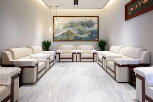 Um espaço de spa com uma pintura grande, diversas áreas de estar e piso de mármore.