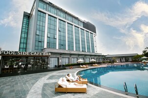 Um hotel moderno com café e área de lounge à beira da piscina.