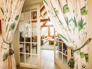 Um quarto com uma grande janela, teto de madeira e um espaço de estar aconchegante com um sofá e uma mesa.