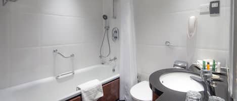Uma casa de banho moderna com banheira, sanita e lavatório.