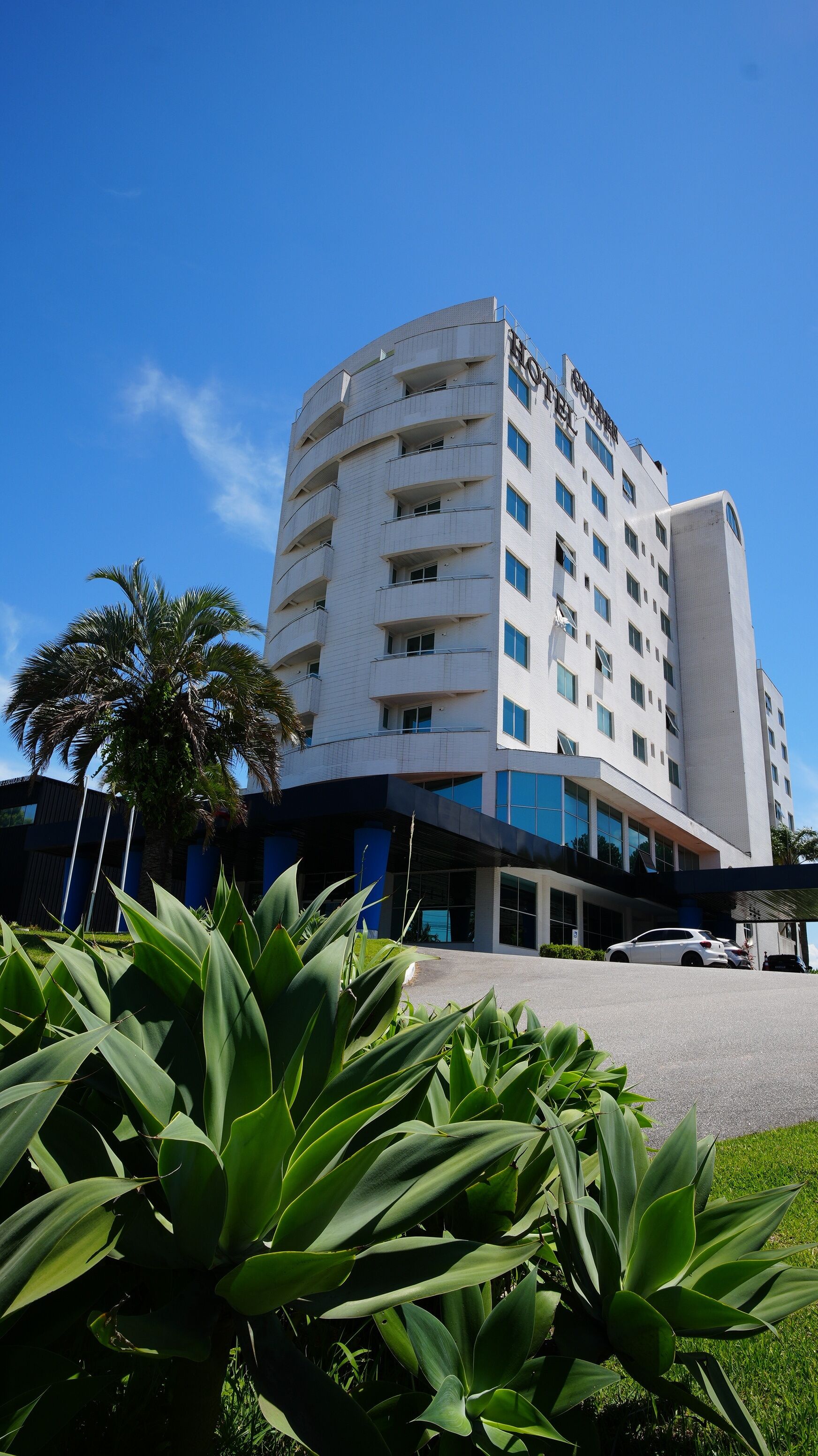 Um hotel com fachada curva, várias varandas e uma placa indicando que se trata de um hotel.