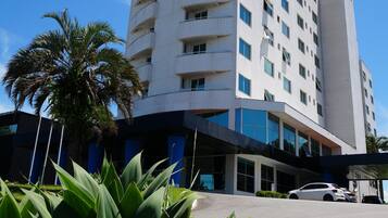 Um hotel com fachada curva, várias varandas e uma placa indicando que se trata de um hotel.