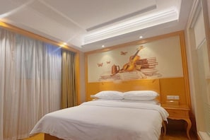 Quarto de hotel com cama, mesa de cabeceira, um quadro na parede e janela com cortinas.