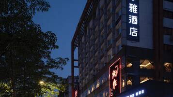 Um hotel com uma placa de destaque para 'Paco Hotel', com a inscrição 'Paco Hotel' em inglês e outro idioma.