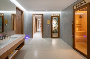 Corredor de hotel com área de massagem nos pés, sauna a vapor e sauna.