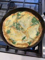 Uma pizza numa assadeira sobre o fogão.