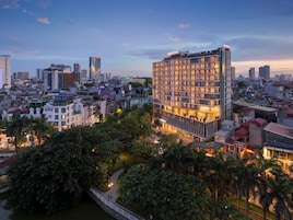 Um hotel moderno com formato retangular, vários andares e uma entrada imponente.