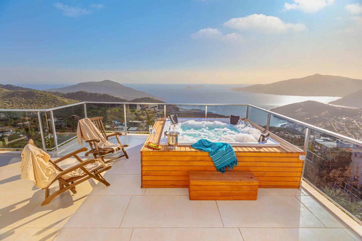 Terraço no topo do prédio com hidromassagem, espreguiçadeiras e vista panorâmica do oceano.