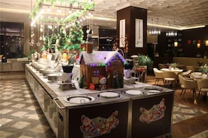 Uma área de buffet com árvore de Natal e decoração festiva.