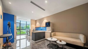 Um hall de hotel moderno com área de estar, ponto de higiene e uma grande janela com vista para o exterior.