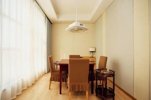 Uma sala de jantar com uma mesa, cadeiras, um abajur e um ventilador de teto.