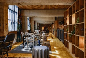 Uma sala de jantar com uma mesa comprida, cadeiras e um armário de madeira com prateleiras.