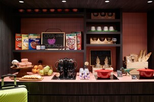 Uma mesa de pequeno-almoço com caixas de cereais, um quadro negro e diversos produtos para o pequeno-almoço.